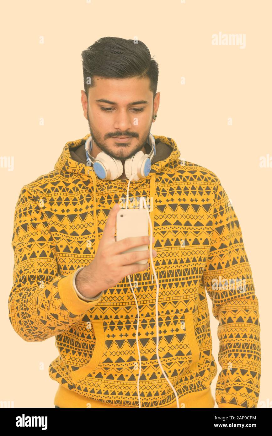 Young handsome Indian man using mobile phone with headphones Stock ...