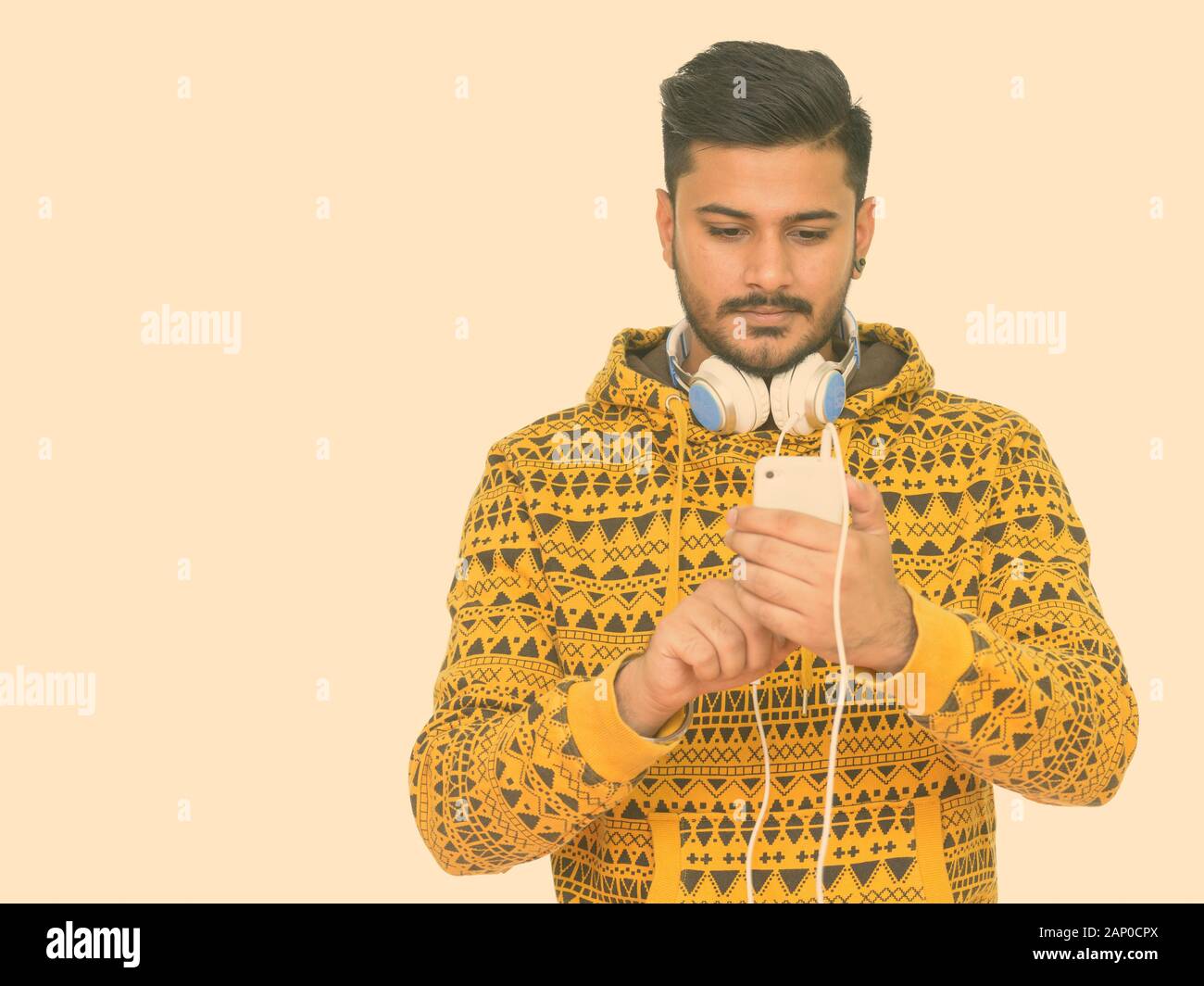 Young handsome Indian man using mobile phone with headphones Stock ...