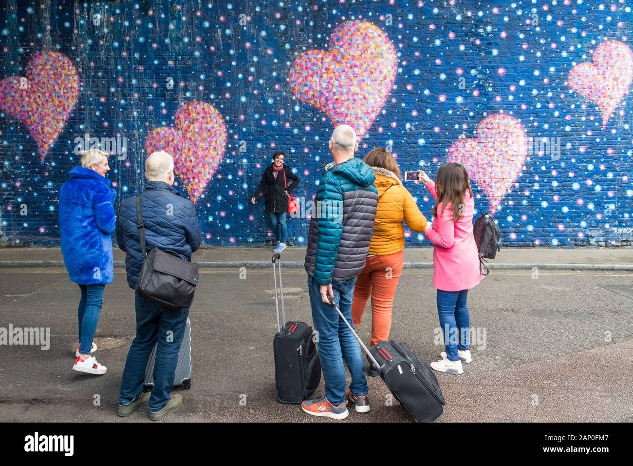 People watching a woman posing for photographs against a large ...