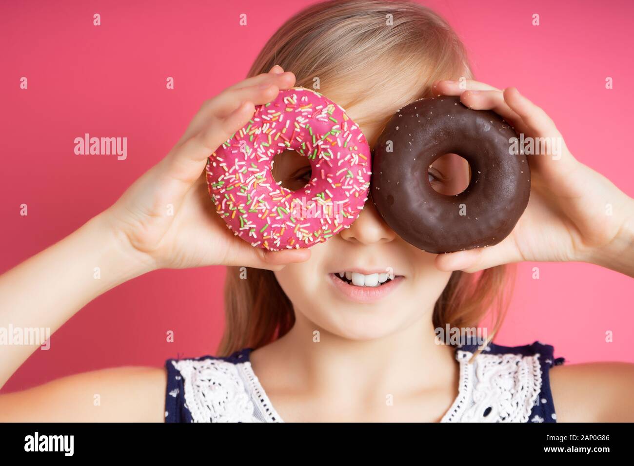 Playful girl holding donuts on her eyes. Woman showing own. White ...