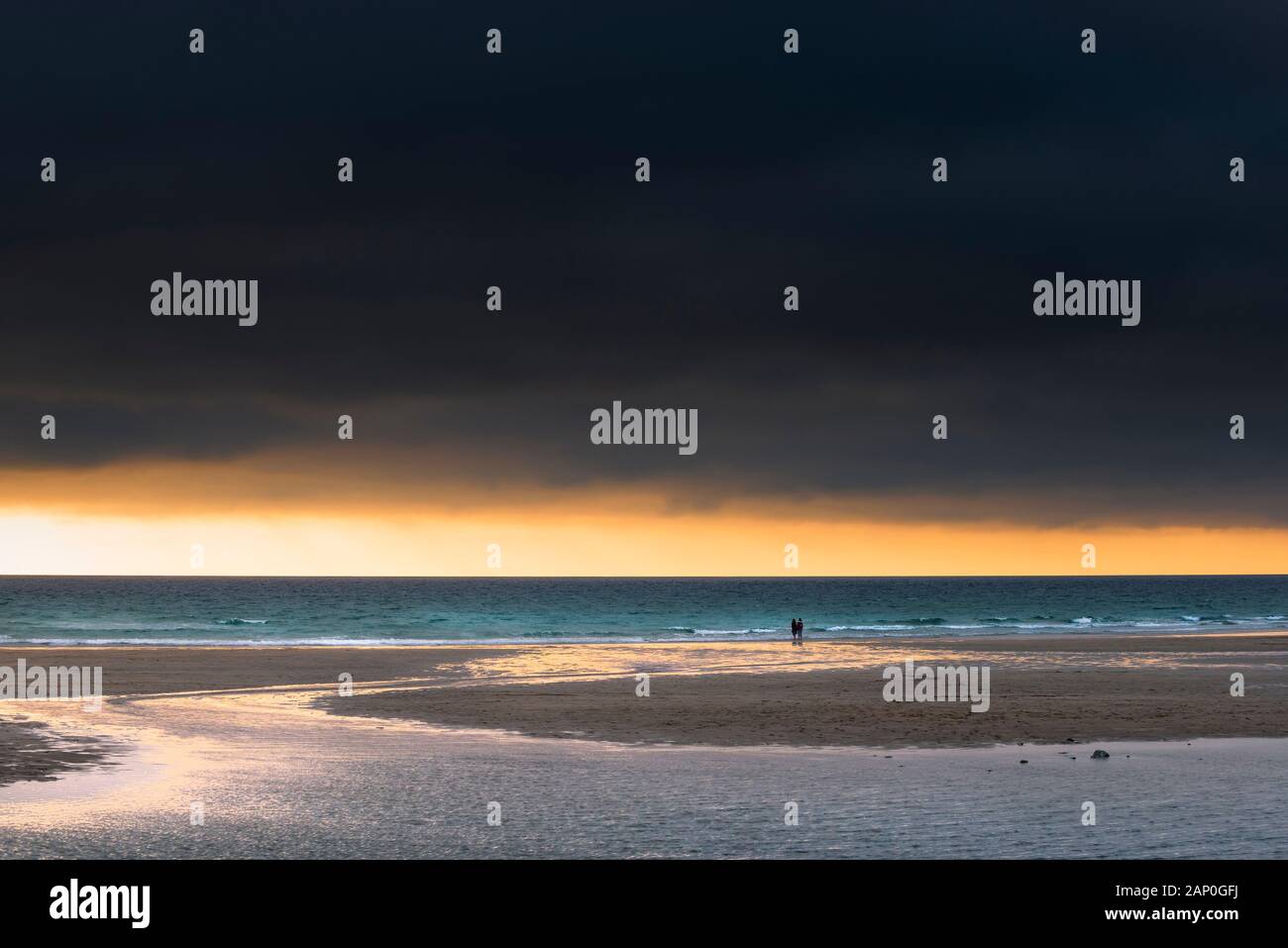 Dramatic dark rain clouds and a golden sunset at Fistral Beach in ...