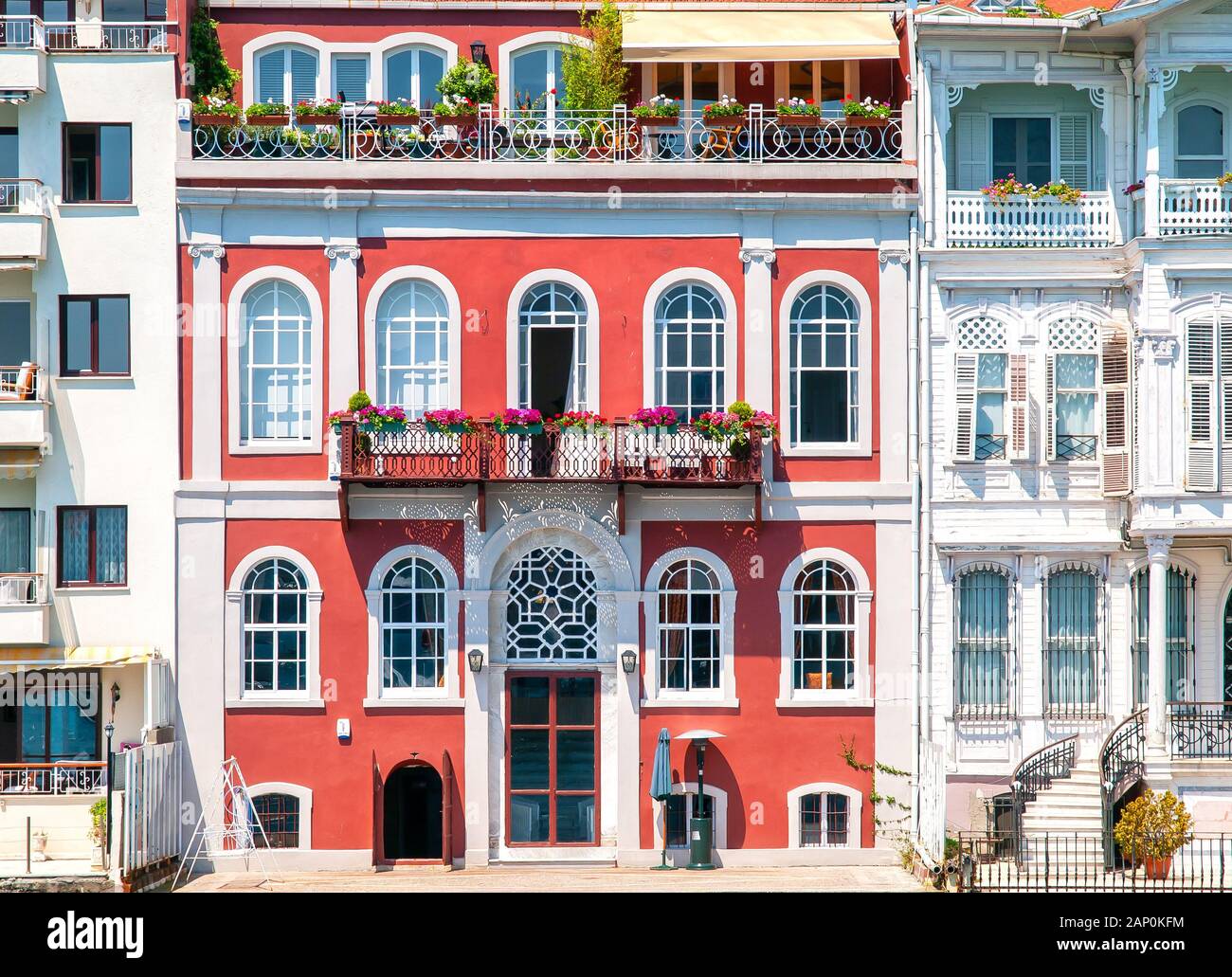 Colorful red mansion with arched windows and beautiful balconies with ...