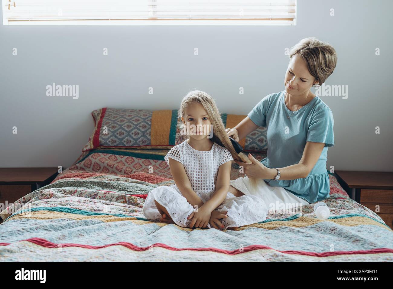 Mother do hair braid to her daughter on the bed Stock Photo - Alamy