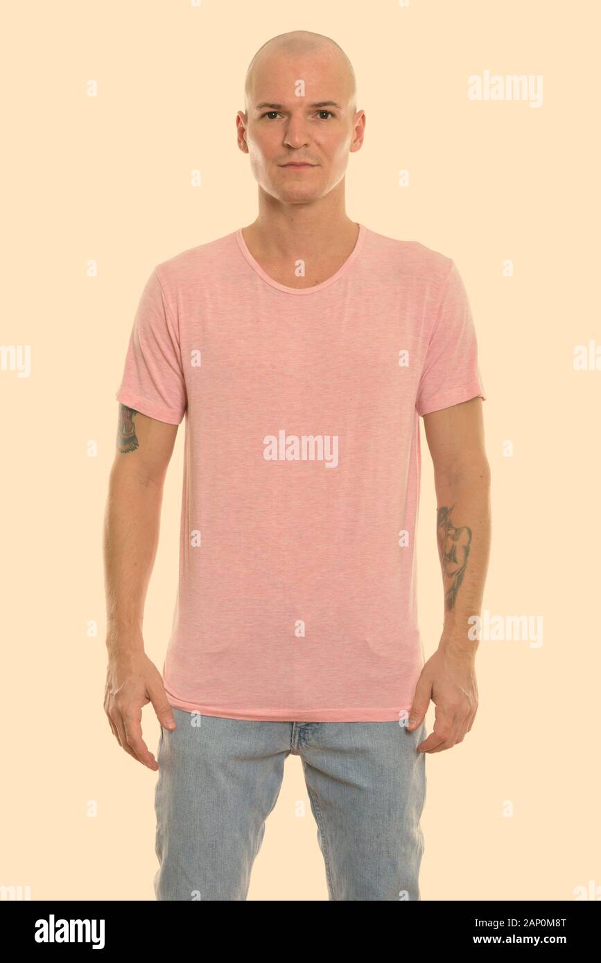 Studio shot of young handsome bald man isolated against white ...