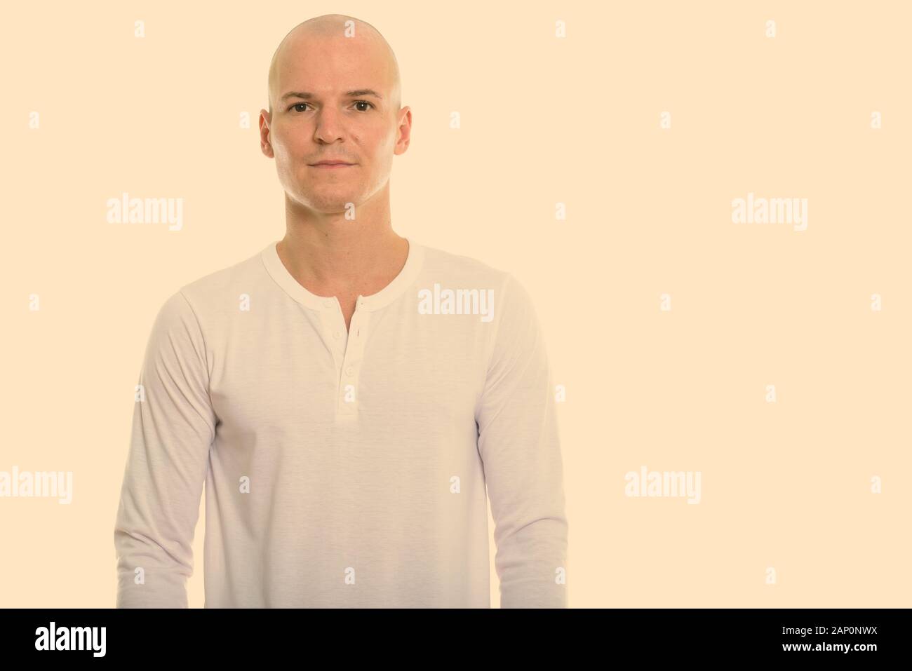 Studio shot of young handsome bald man isolated against white ...