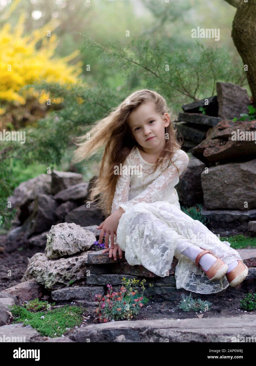 Adorable six years old little girl wearing white festive dress, posing ...