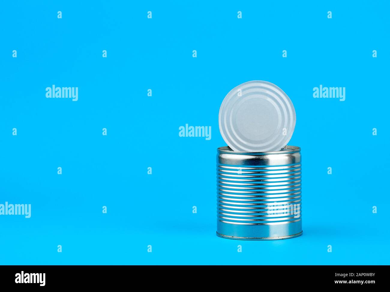 open hard iron can for food preservation on a blue background, copy ...