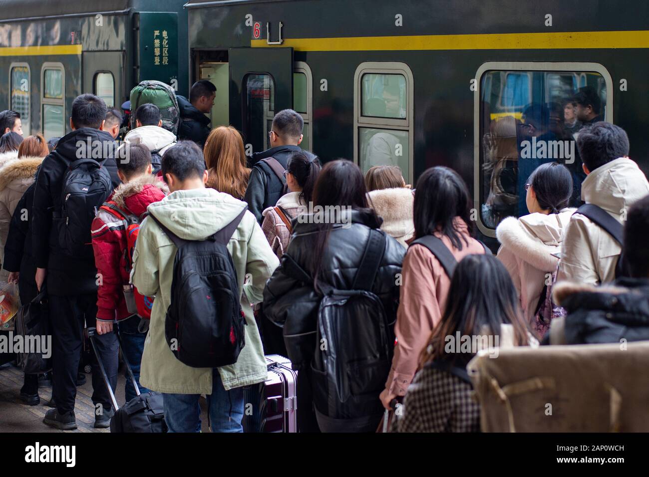 Chinese passengers queue up to board a train to go back home for the ...