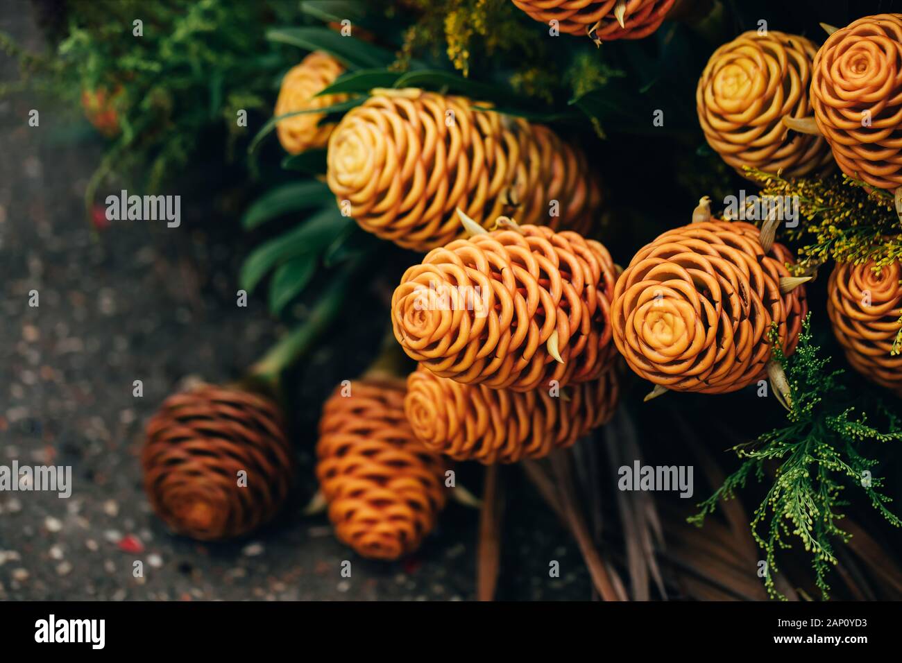 Bouquet of golden beehive ginger in a basket on the concrete floor ...