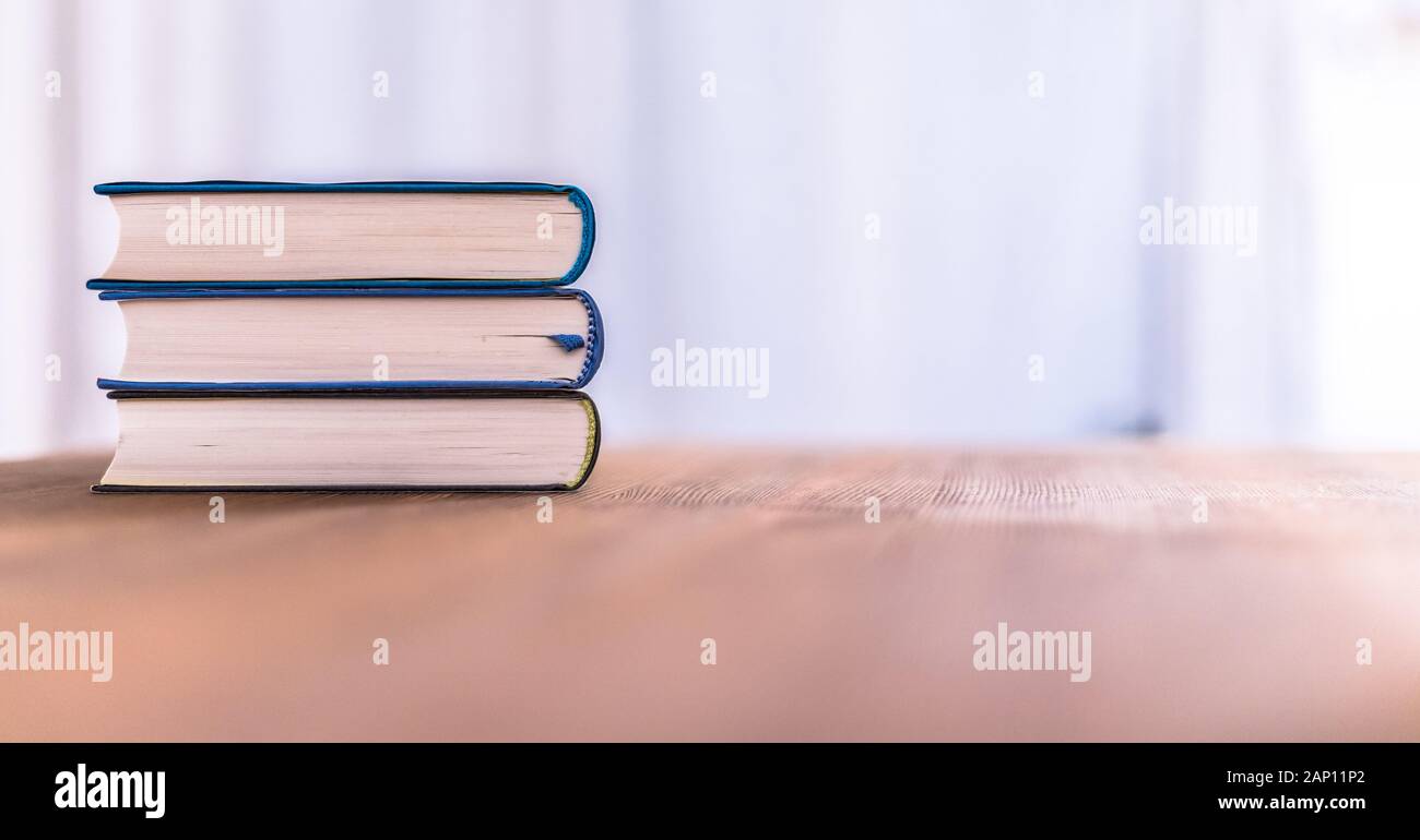Stack of books lying on wooden desk at home. Knowledge and science ...