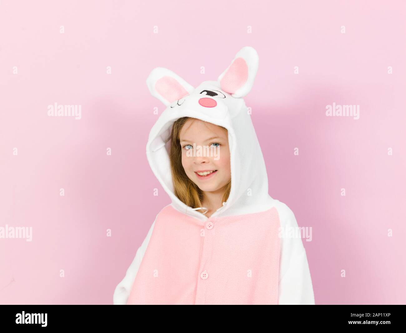 pretty blonde girl with cozy rabbit costume is posing in the studio ...