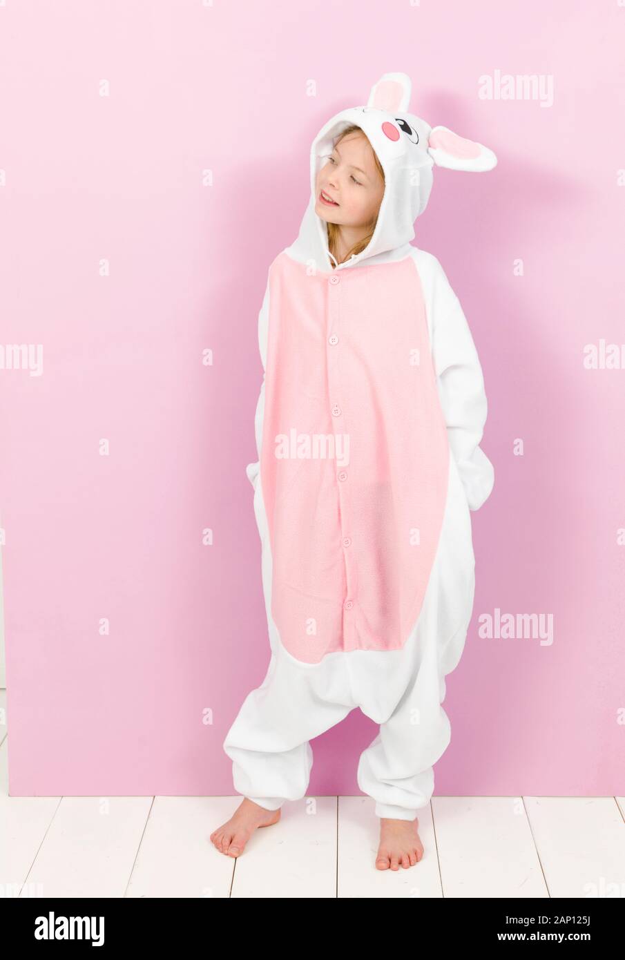 pretty blonde girl with cozy rabbit costume is posing in the studio ...