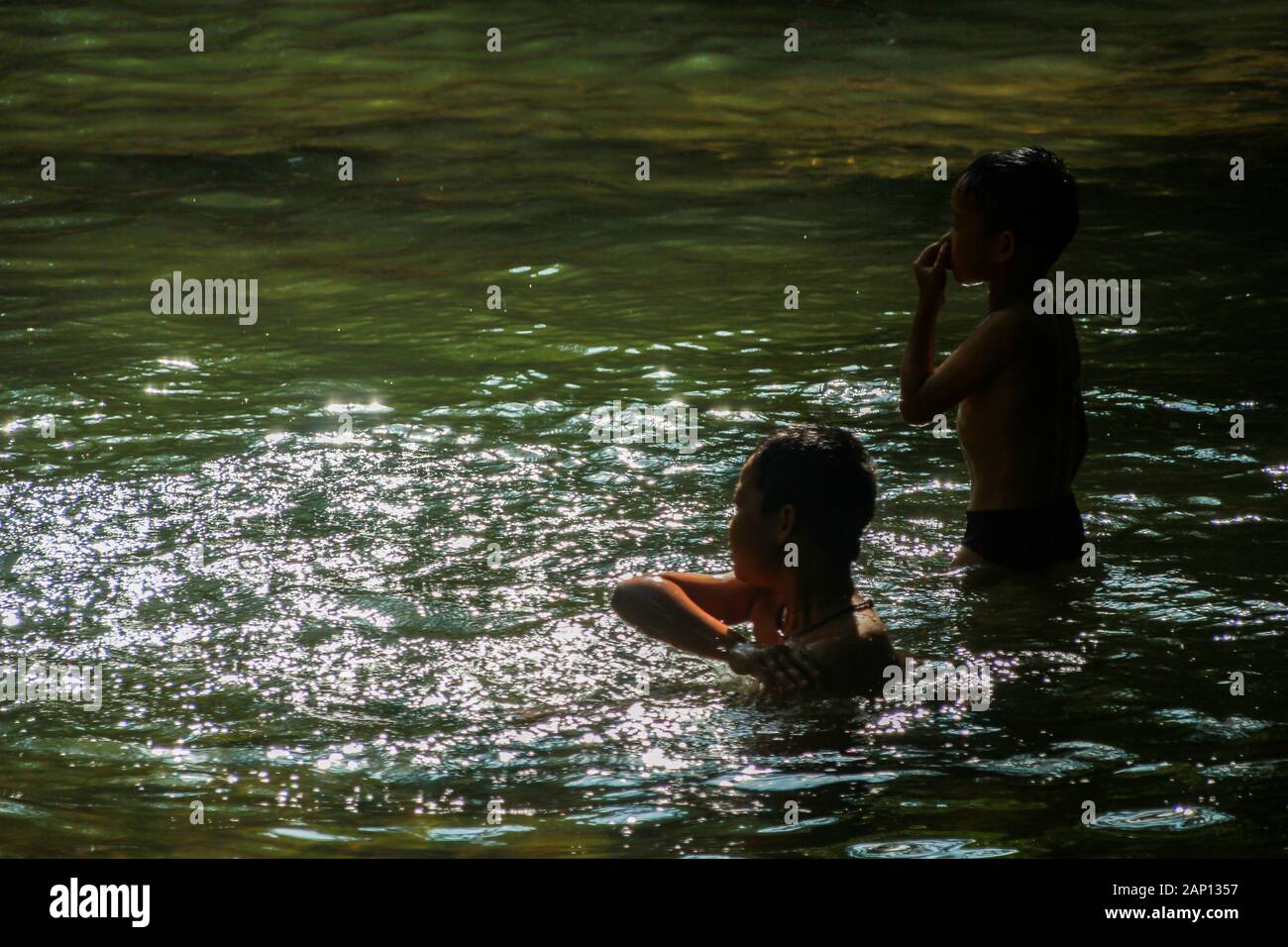 Two children are playing in the waterfall in a fun way Stock Photo - Alamy