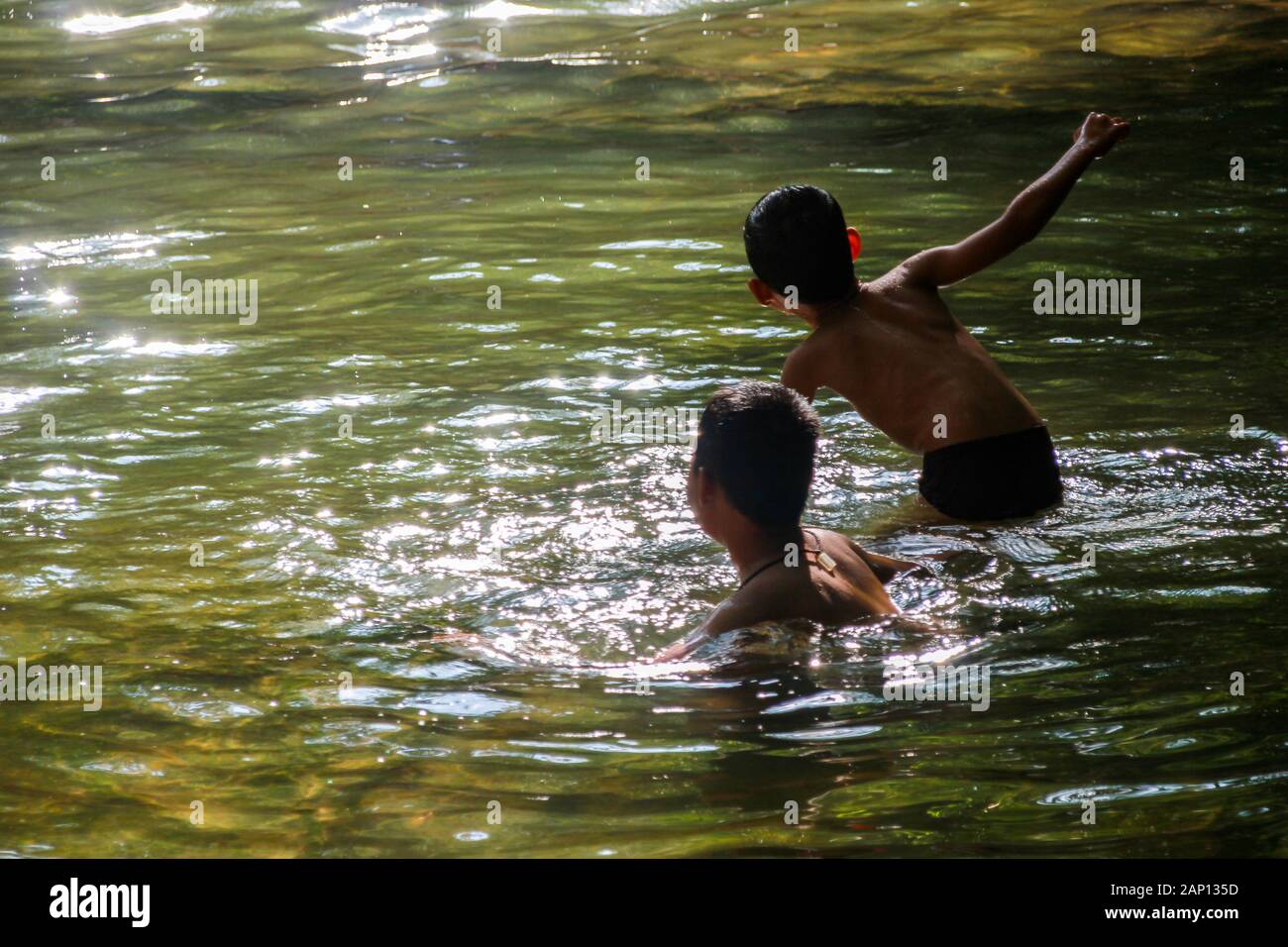 Two children are playing in the waterfall in a fun way Stock Photo - Alamy