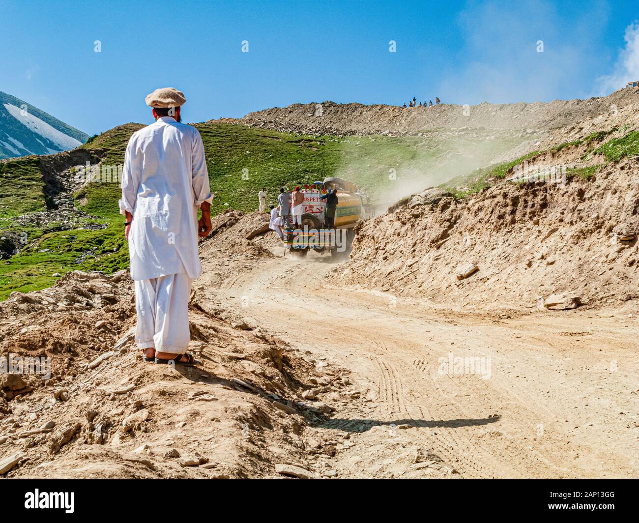Local man watching his friends hitching a ride on a petrol truck up to ...