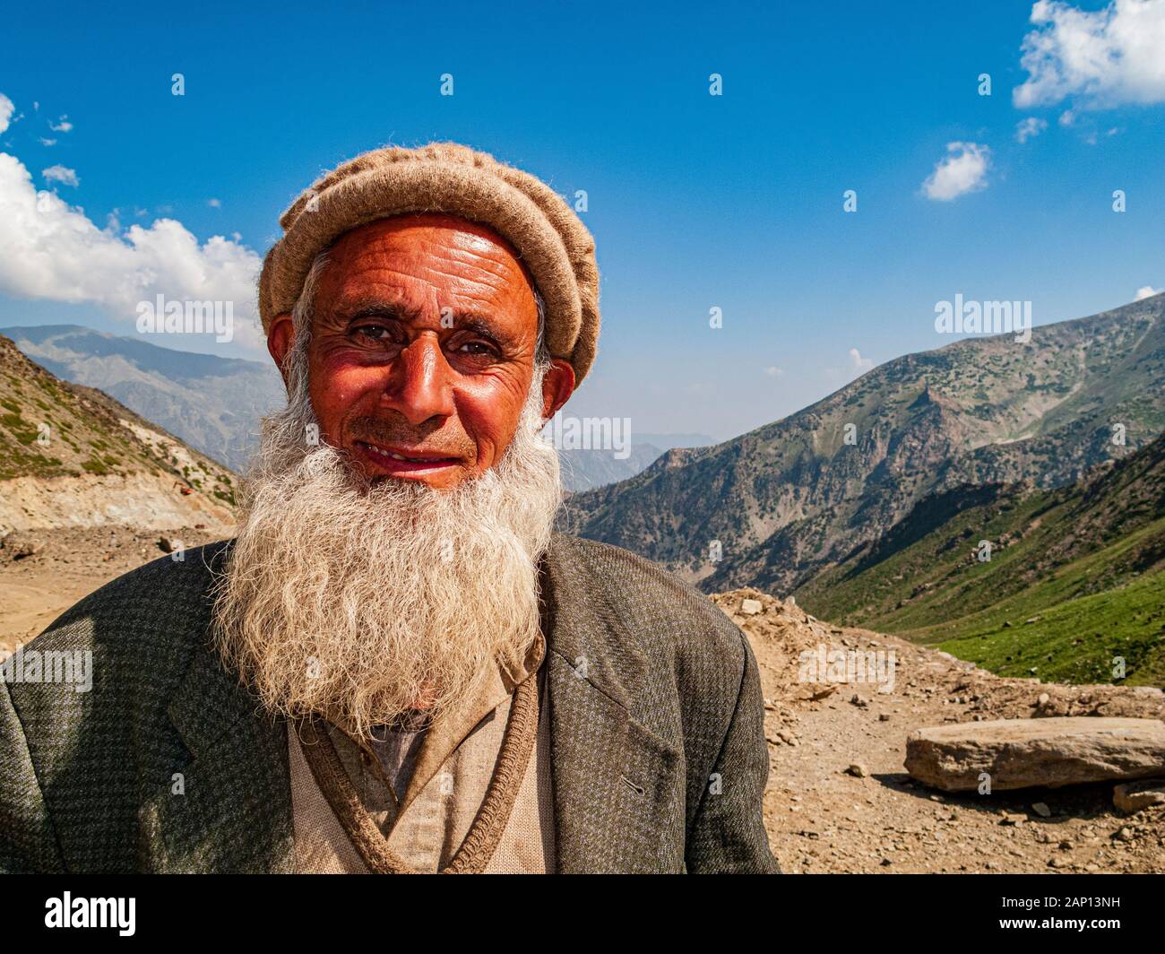 Portrait of a local man walking up the dusty road to Babusar Pass Stock ...