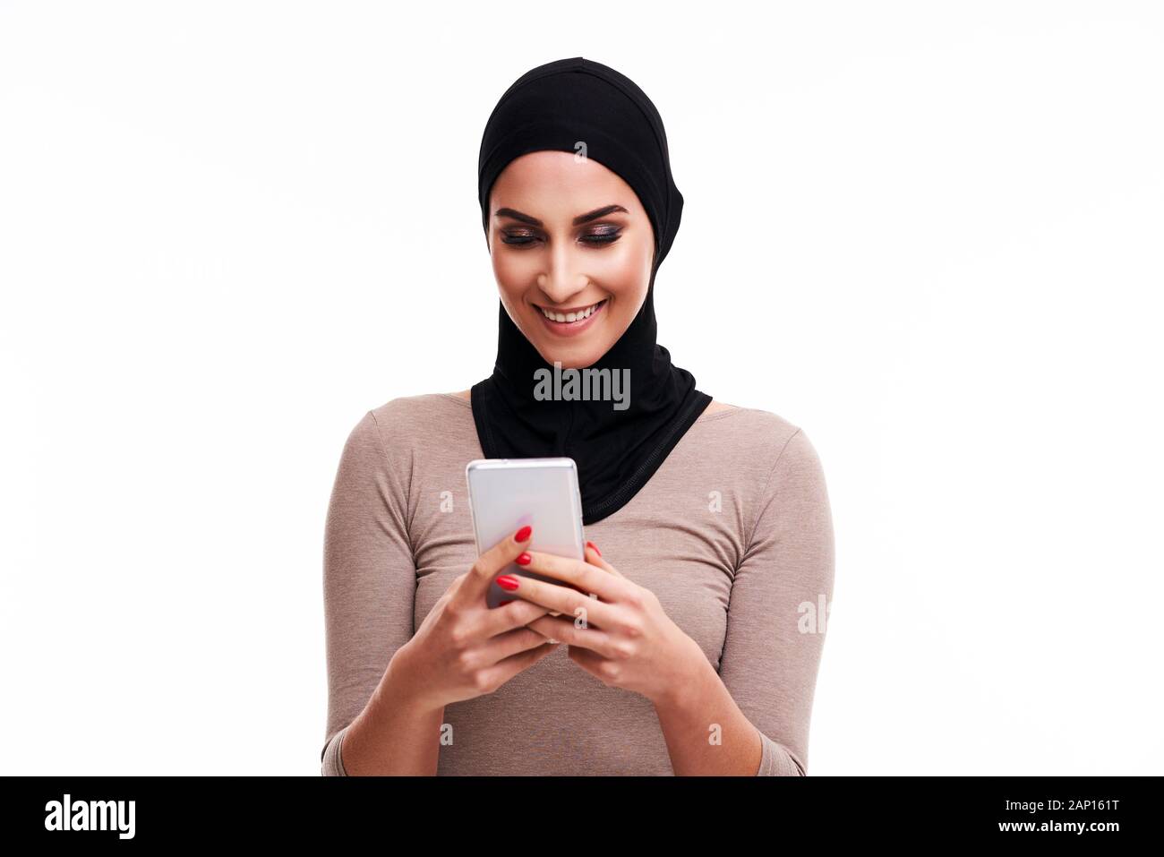 Muslim woman using smartphone over white background Stock Photo - Alamy