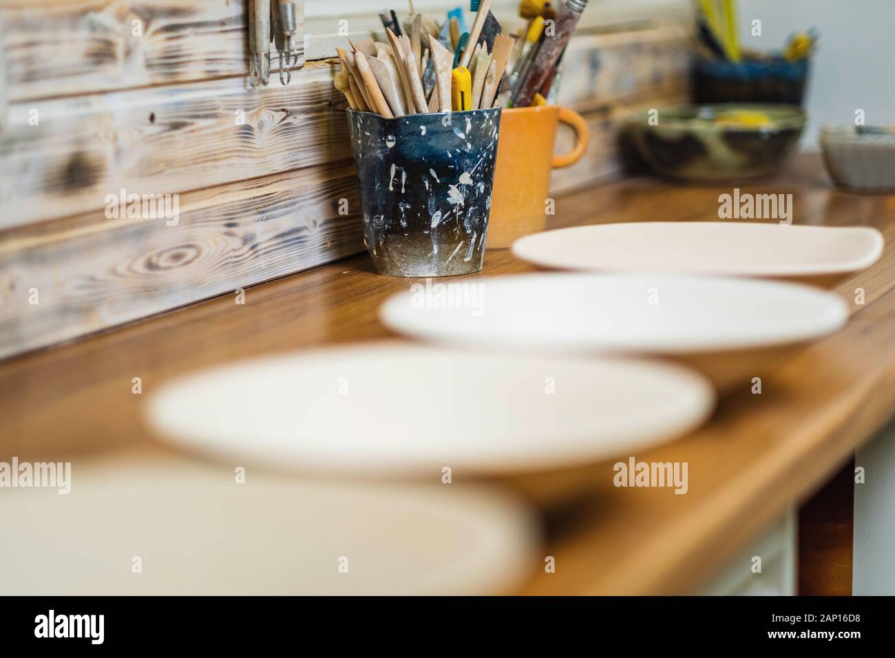 Plates and tools on pottery studio table, shallow debt of field, small ...