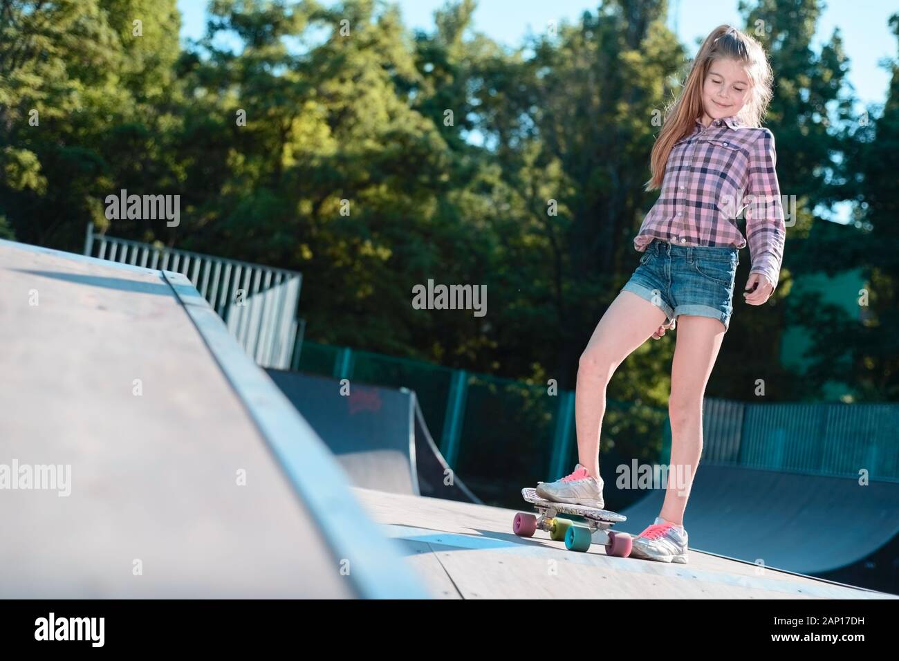 Skater female rides on skateboard at skate park ramp. Young woman ...