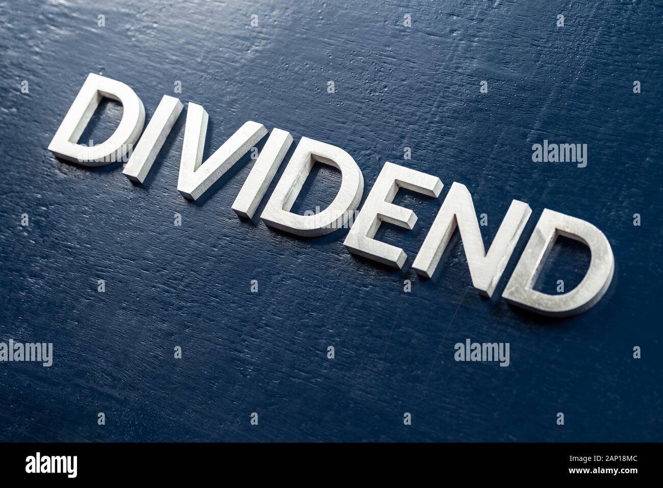 the word dividend laid by silver metal letters on gloss painted board ...
