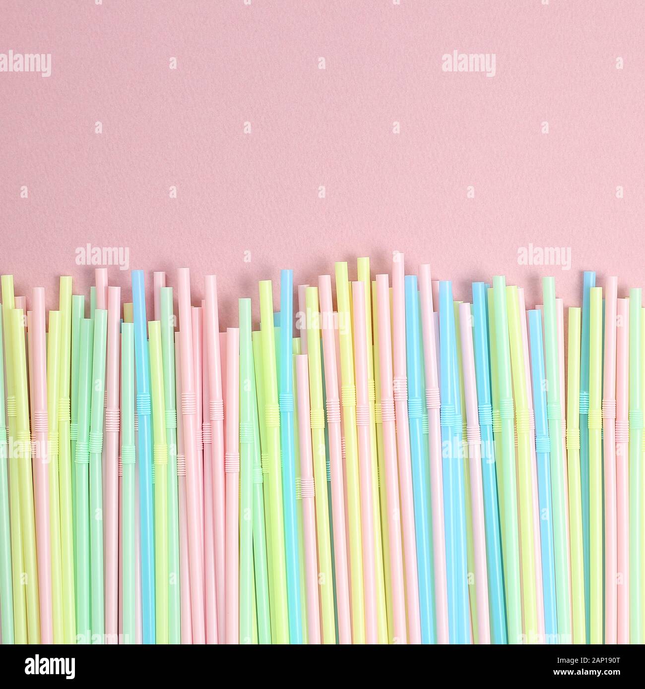 Pastel color straws on pink background Stock Photo - Alamy