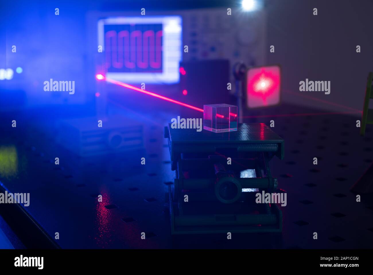 Experiment in optic lab with laser device. Red laser on optical table ...