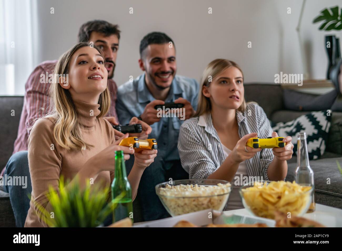 Cheerful friends competing in video games, having fun together.People ...