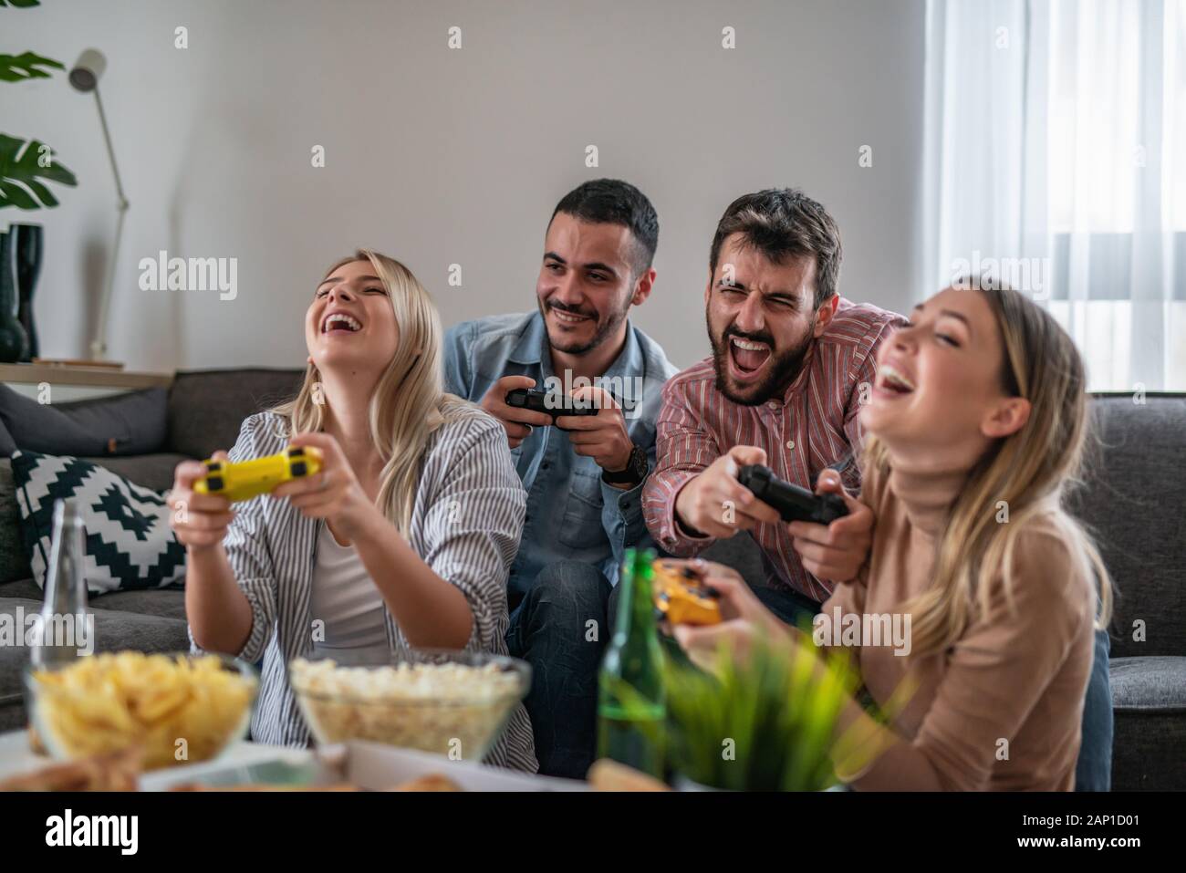 Cheerful friends competing in video games, having fun together.People ...