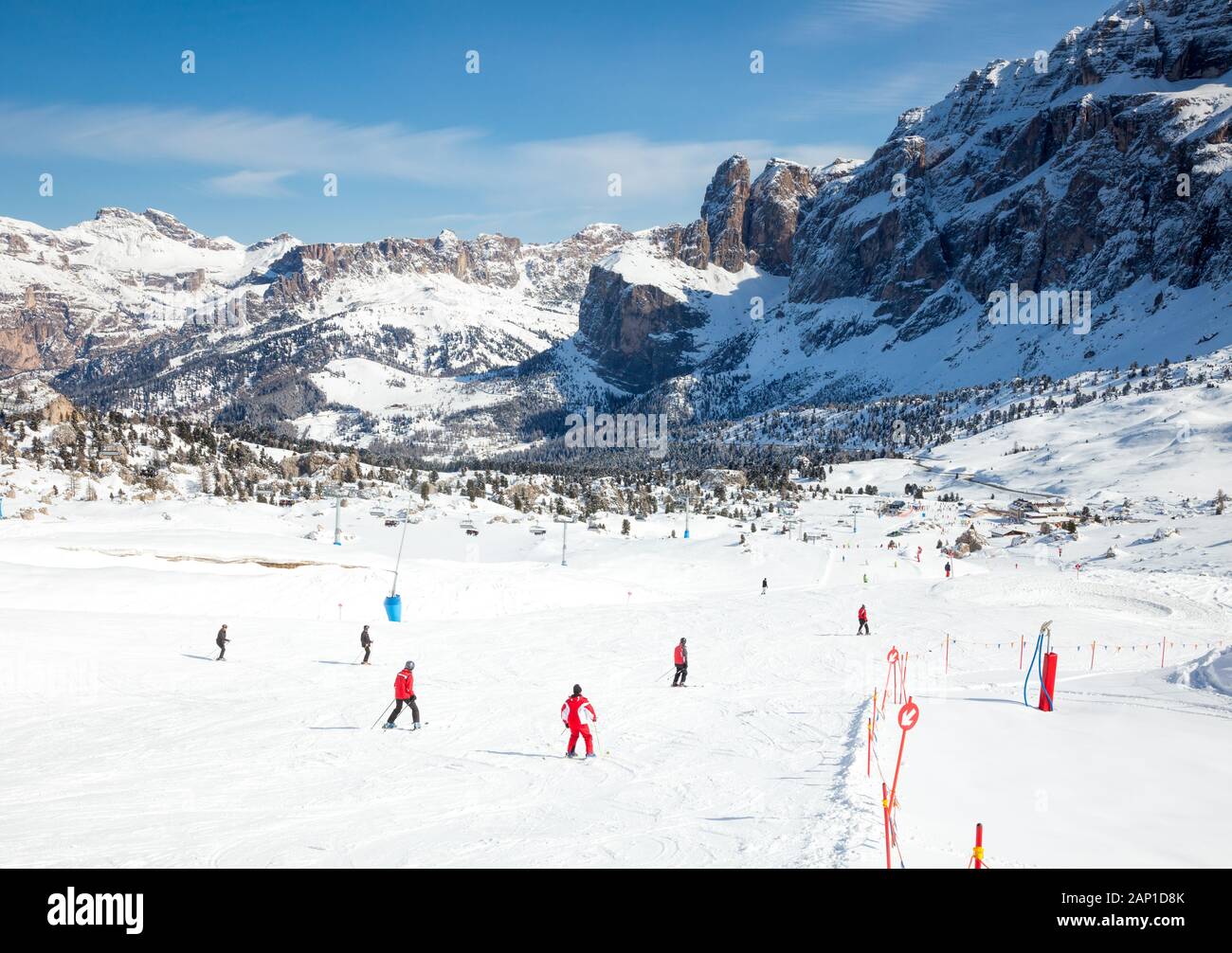 Skiers going down the slope at Sella Ronda ski route in Dolomites ...