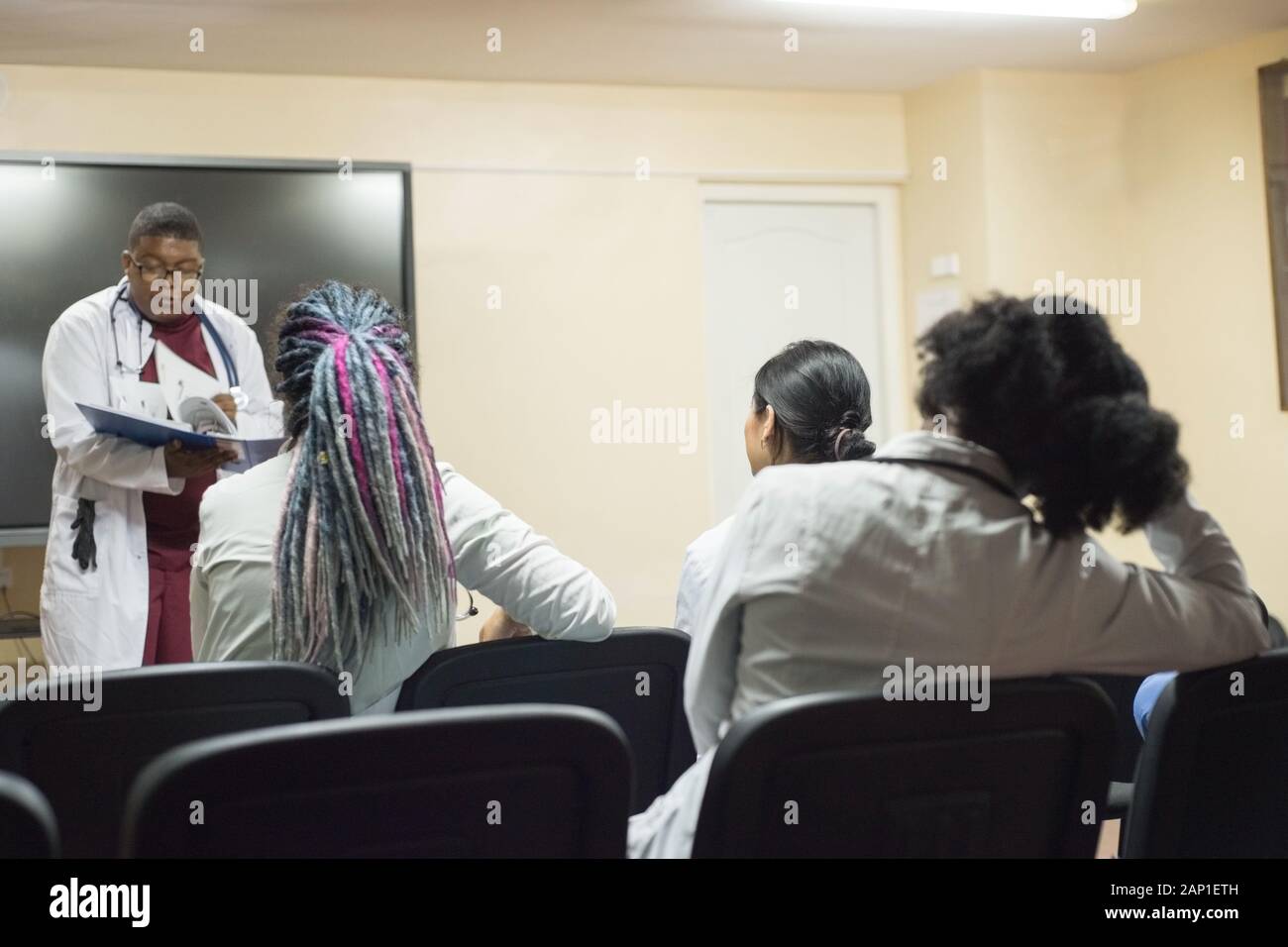 doctors, mixed race, in the classroom, at a medical conference. Young ...