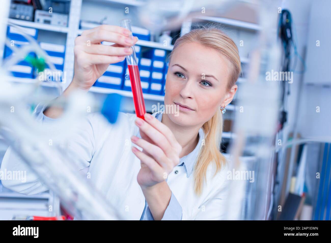 Female laboratory assistant with chemical experiment in scientific ...