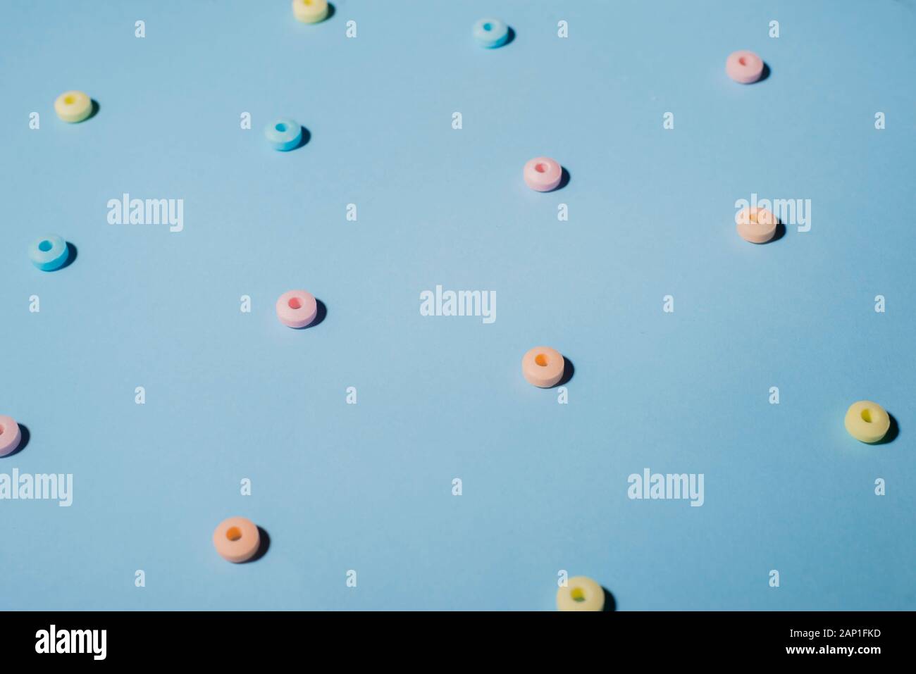 multi-colored round sweets, with a hole in the center. On a blue ...