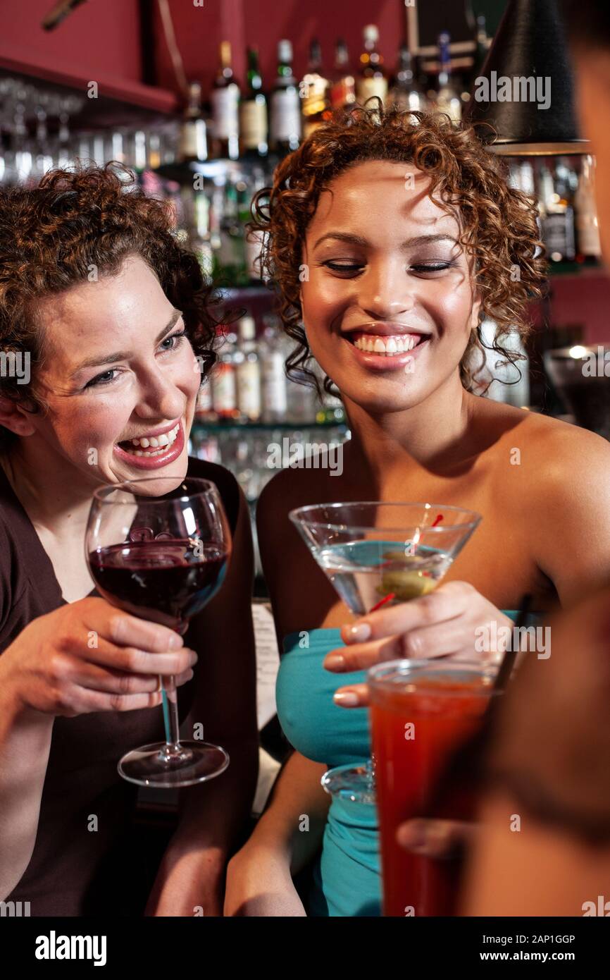 Millennial women with drinks in hand at a local bar Stock Photo - Alamy