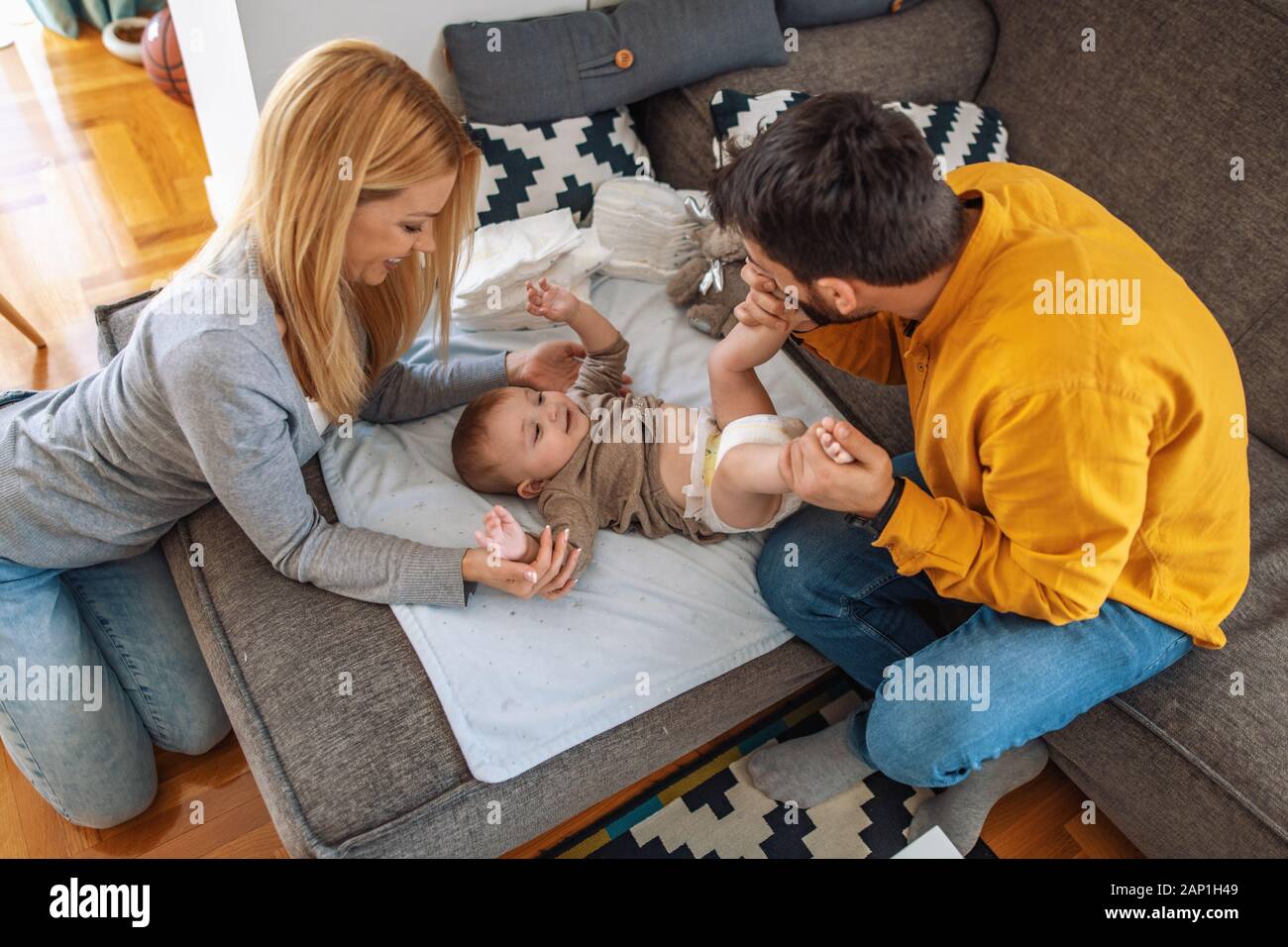 Happy parents changing diaper to their baby boy Stock Photo - Alamy