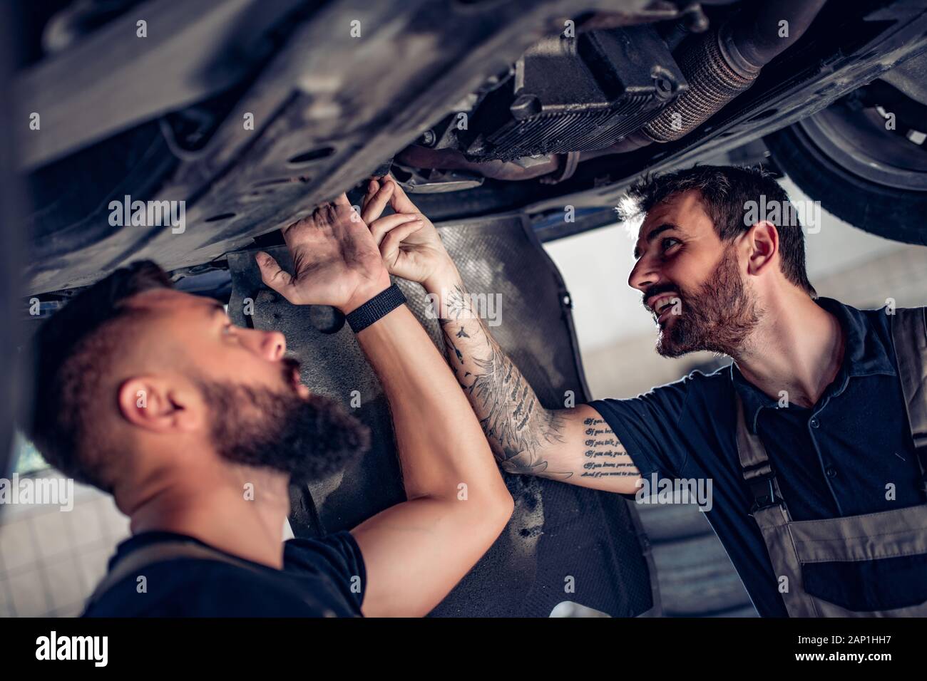 Handsome mechanics examining car hi-res stock photography and images ...