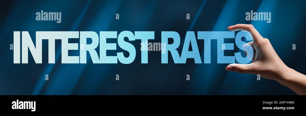 Female hand holding interest rates description over blue abstract ...
