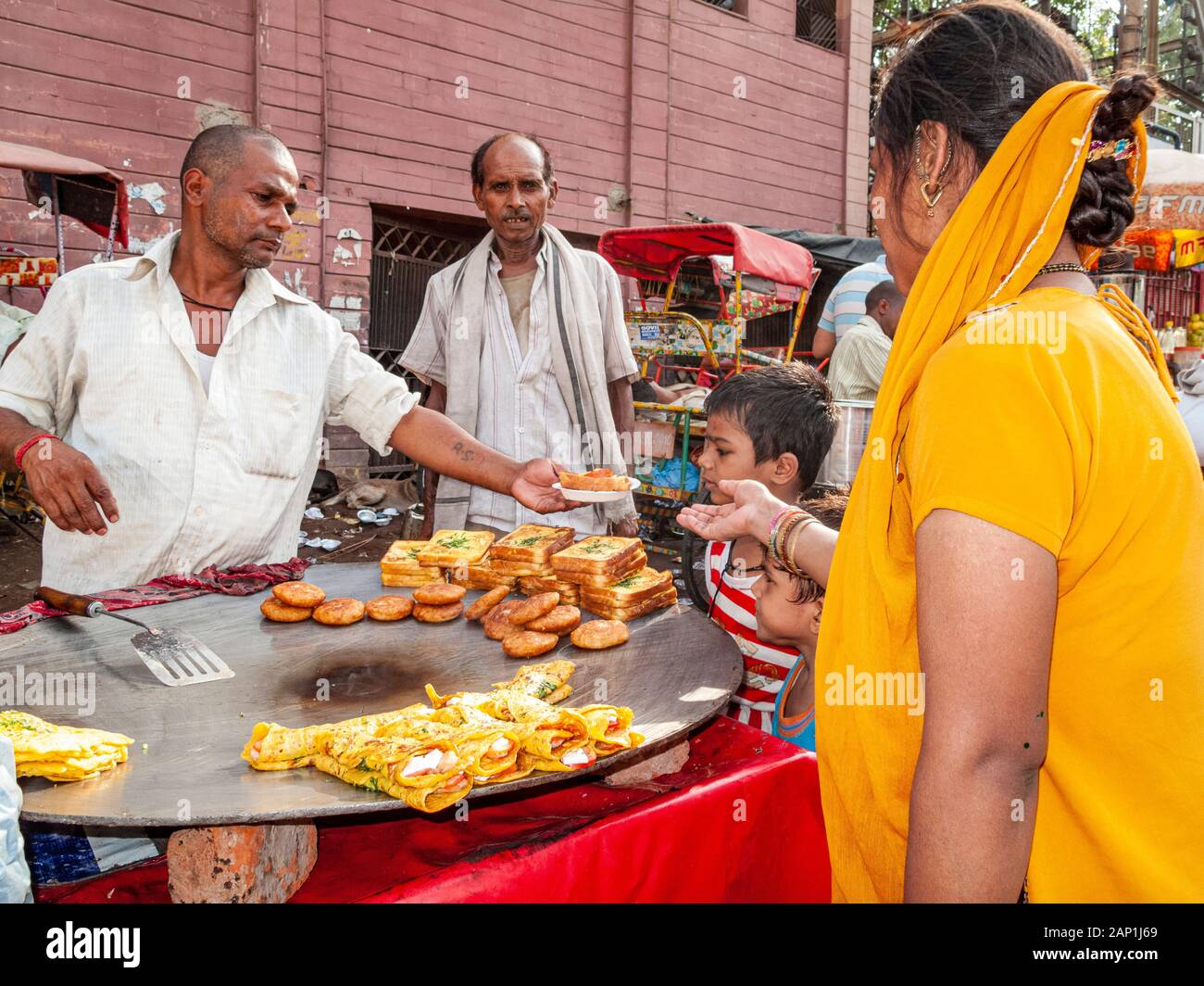 A vendor is selling delicious snacks in the street bazaar Stock Photo ...