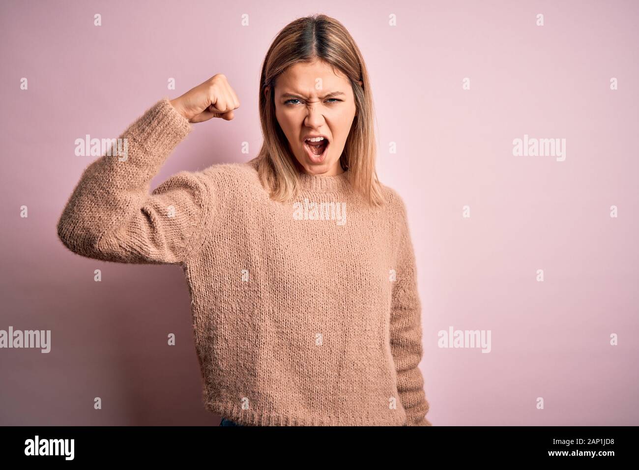 Young beautiful blonde woman wearing winter wool sweater over pink ...