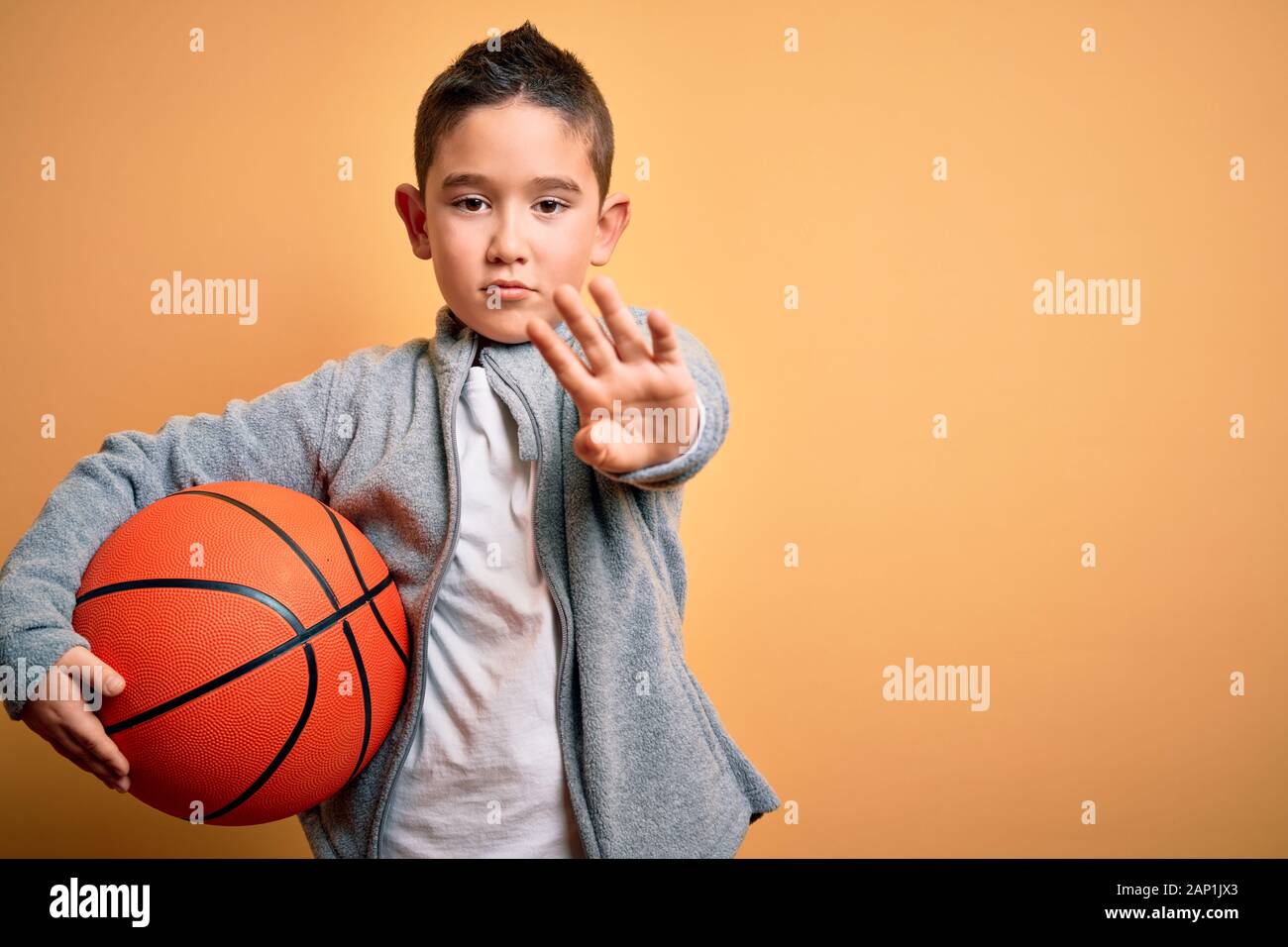 Young little boy kid playing with basketball game ball over isolated ...