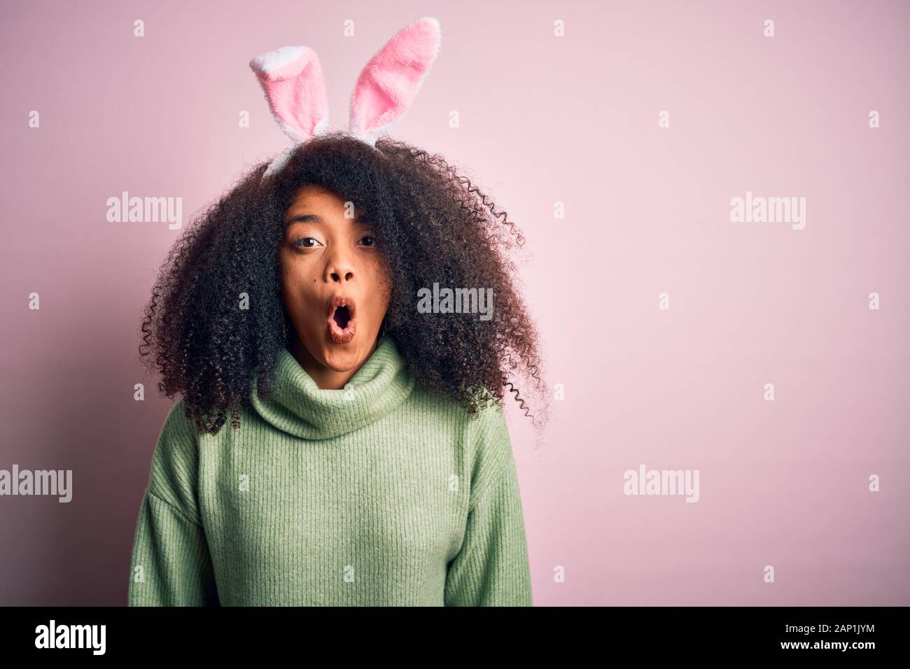 Young african american woman with afro hair wearing easter rabbit ears ...