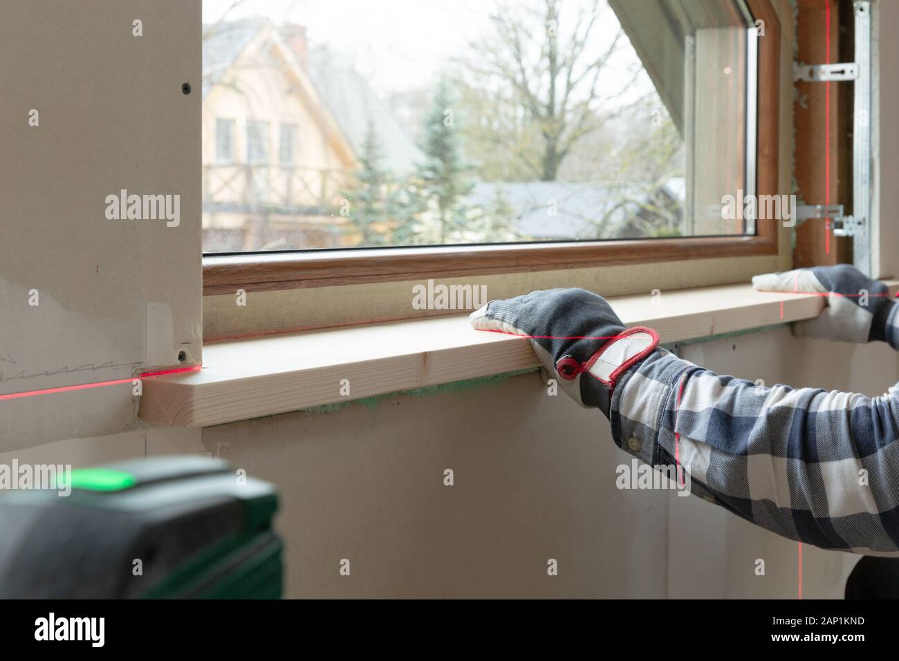 home improvement handyman installing window sill in new build attic by ...