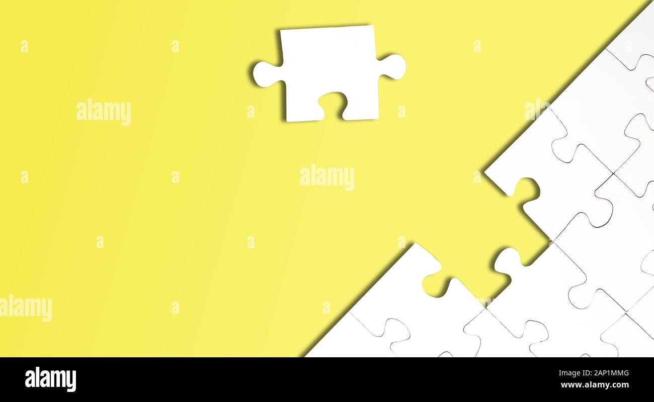 top view of jigsaw puzzle with one piece left on bright yellow ...