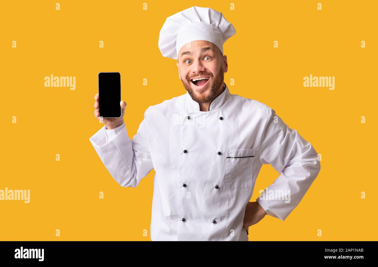 Excited Chef Showing Mobile Phone Empty Screen On Yellow Background ...