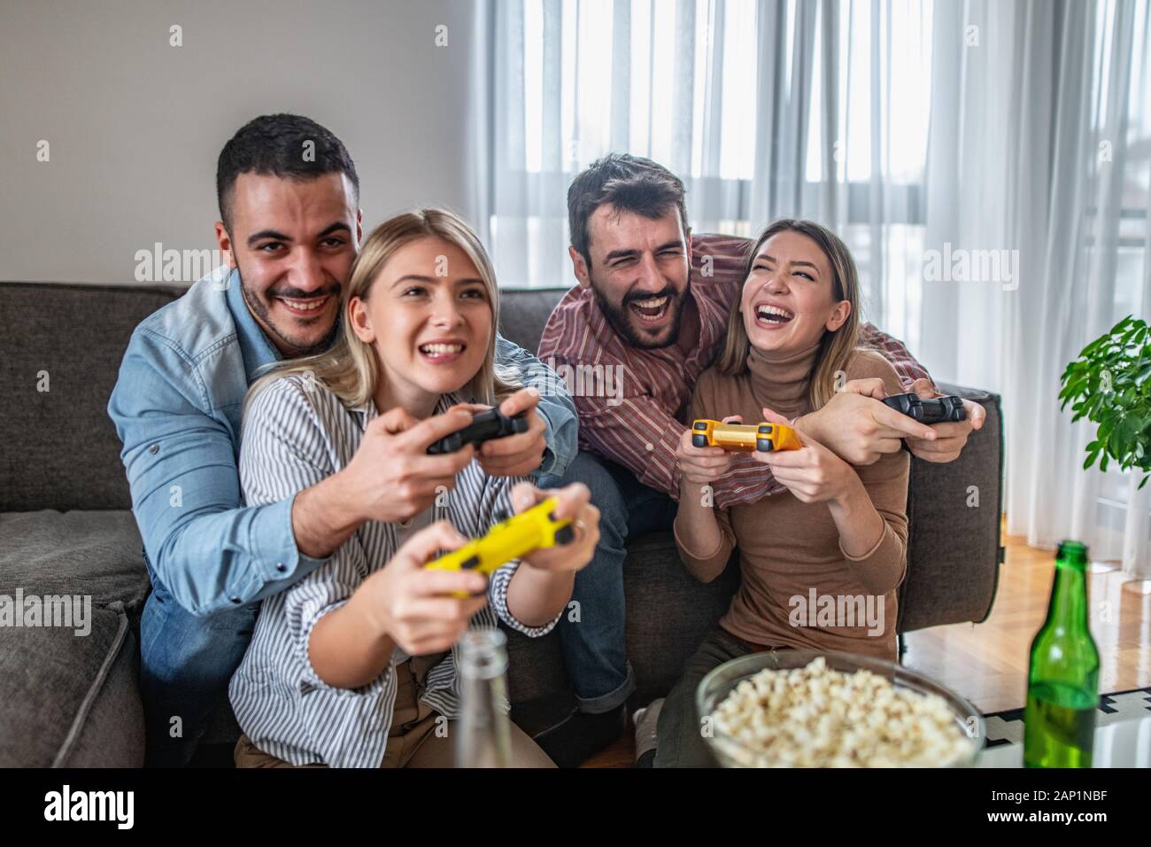 Cheerful friends competing in video games, having fun together.People ...