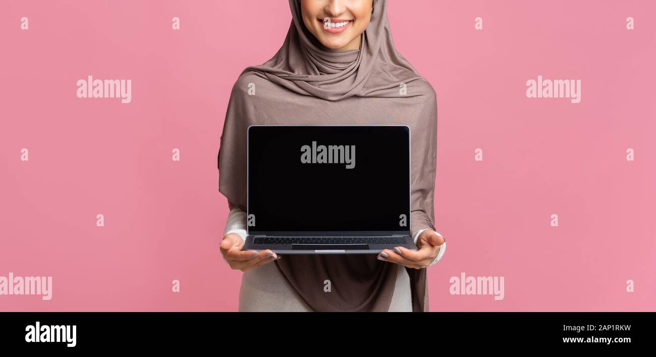 Muslim lady in hijab demonstrating black screen of laptop computer ...