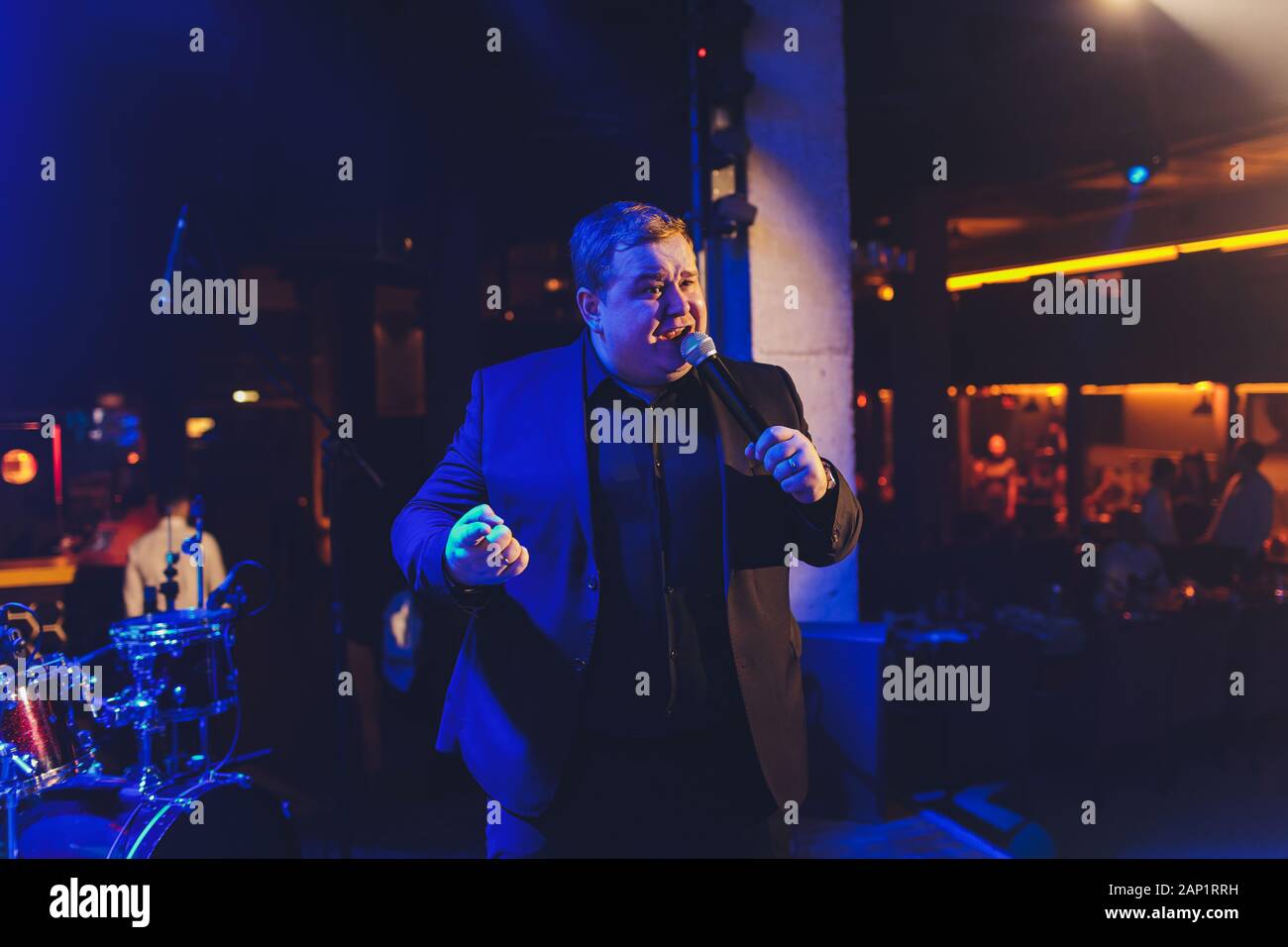 Singer performs on the stage illuminated by lights Stock Photo - Alamy
