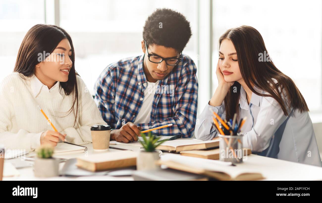 High school students studying and reading together in library Stock ...