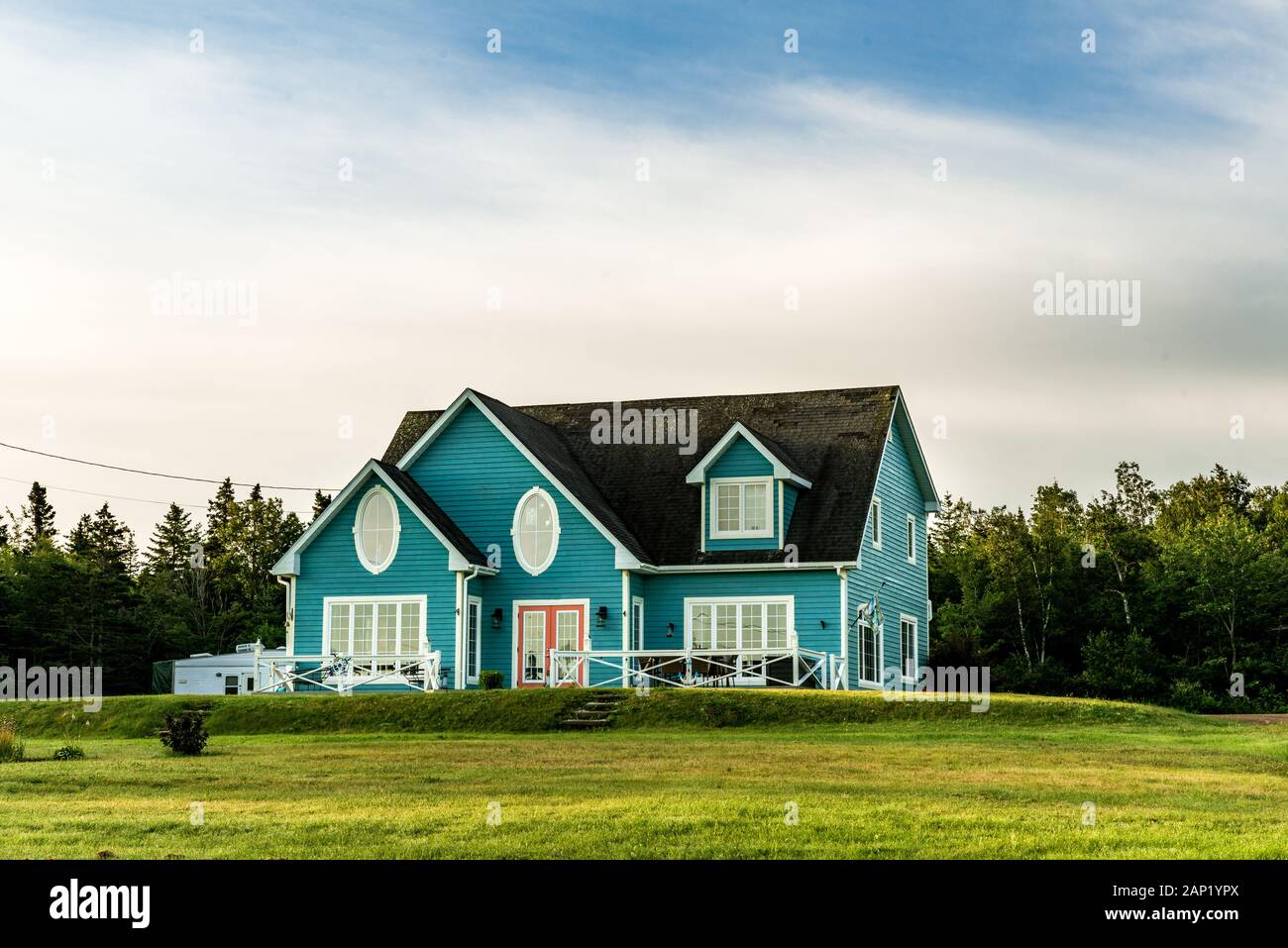 Blue cottage style home with great patio, lawn and porch. Traditional ...