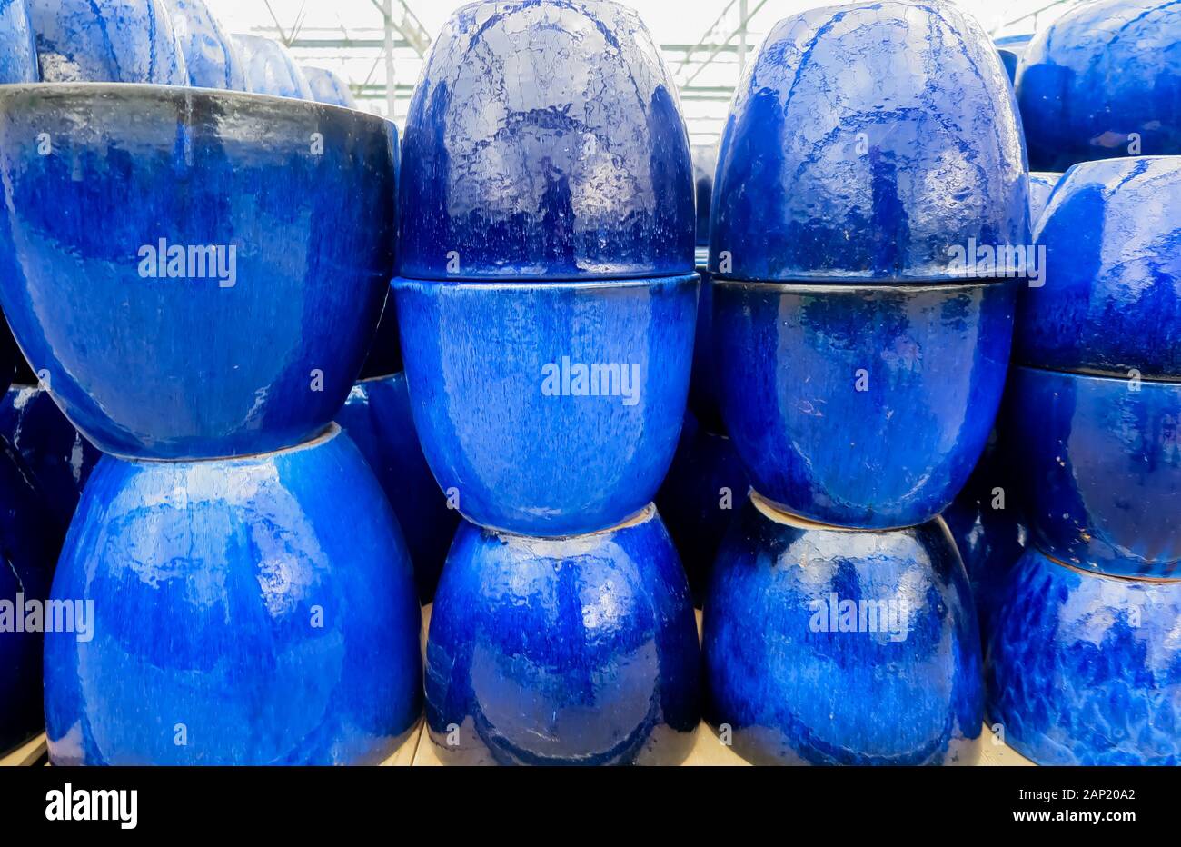 View on stapled pile of terra cotta flower pots painted in shiny ...