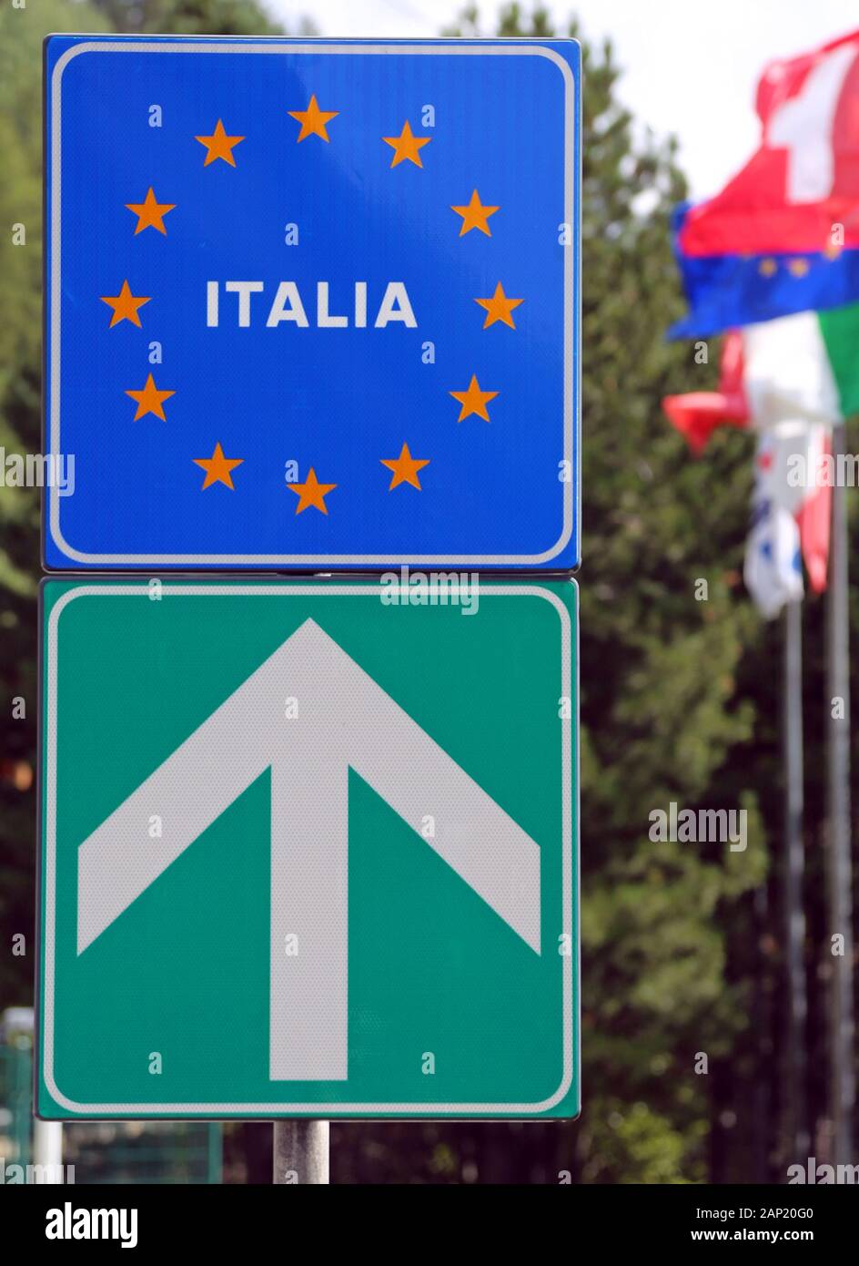 Italian border road sign on the alps with flags in the background Stock ...